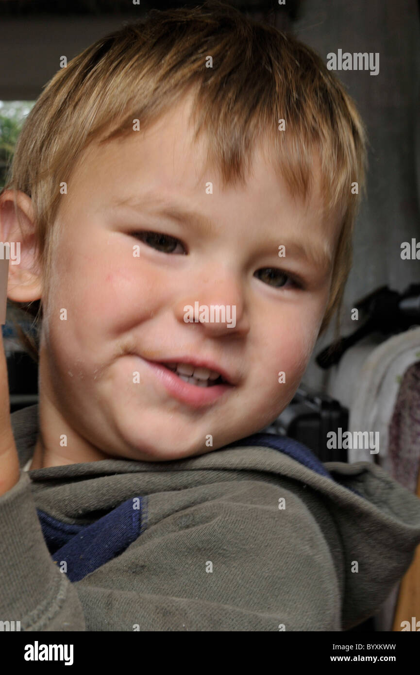 Baby boy looks out with mischievous look Stock Photo - Alamy