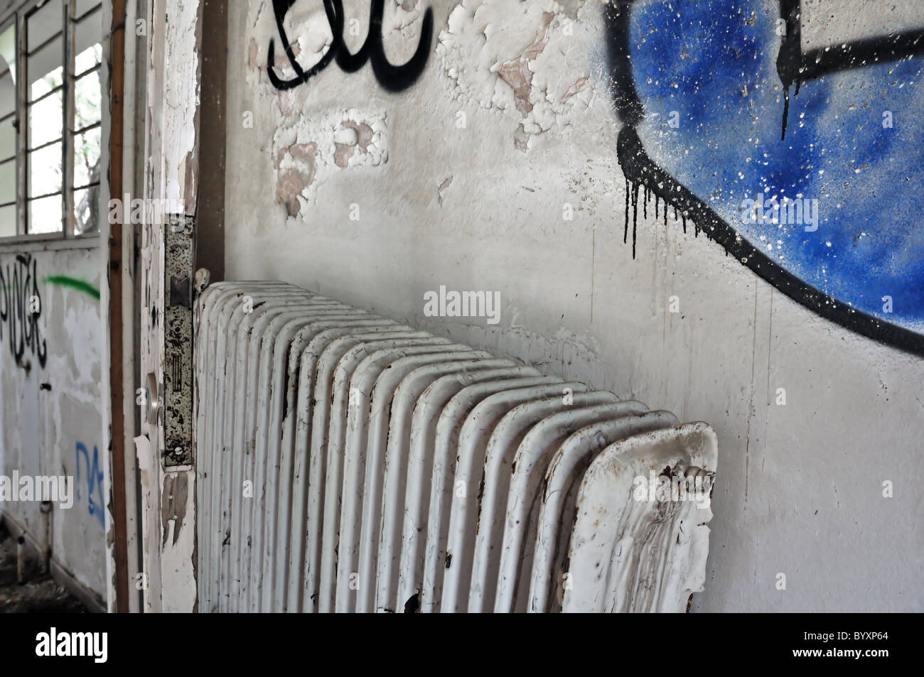 Radiator and stained peeling wall in abandoned building Stock Photo - Alamy