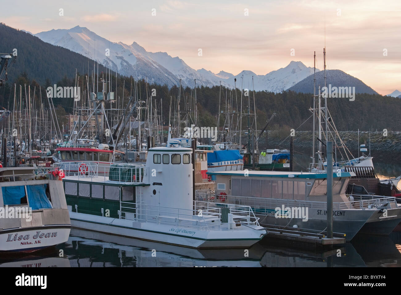 Crescent harbor and snow capped mountains during a winter sunrise in ...