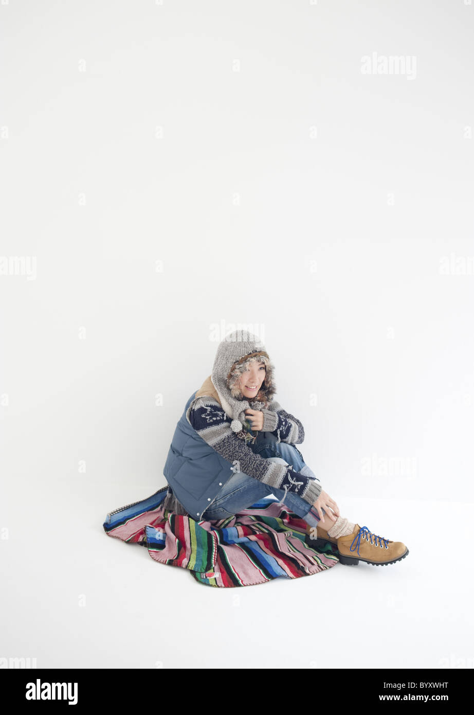 Young woman sitting on rug Stock Photo - Alamy