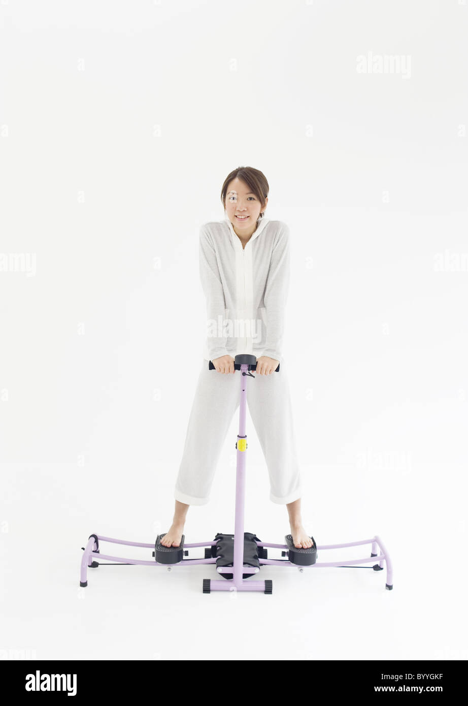 Young woman using leg machine Stock Photo - Alamy