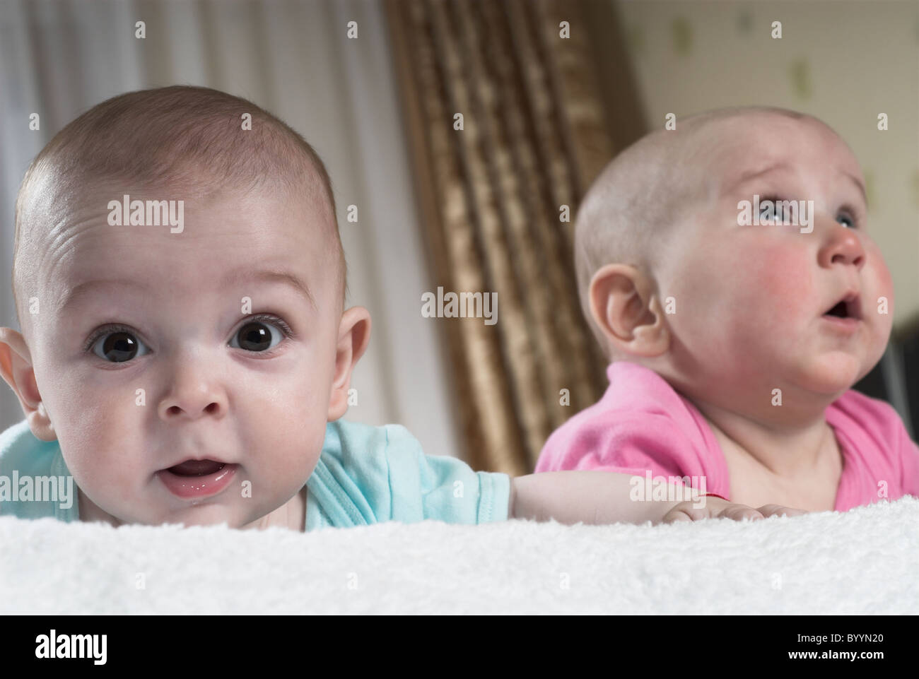 Two cute babies is looking in different ways Stock Photo - Alamy