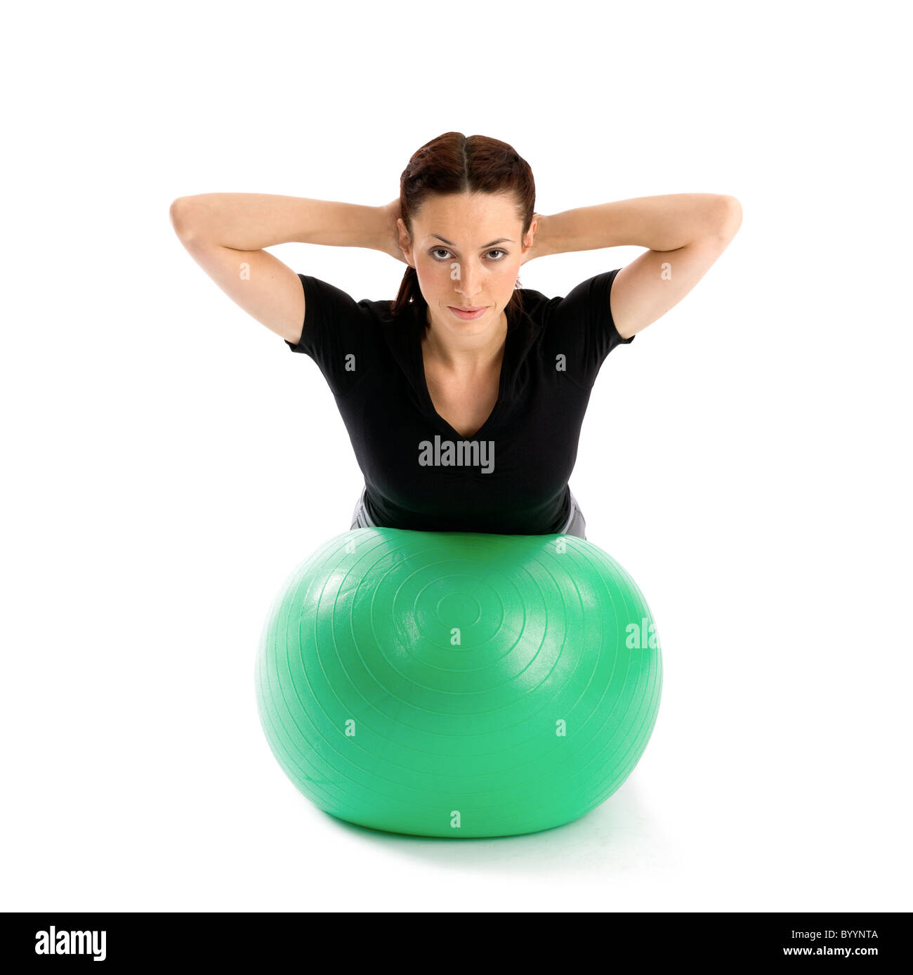 Pretty woman with hands behind head doing a pilates exercise using gym ...