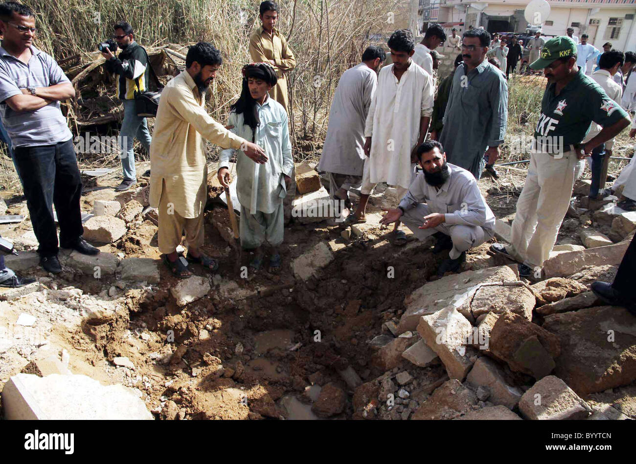 People look crater caused by explosion after explosion behind Shah ...