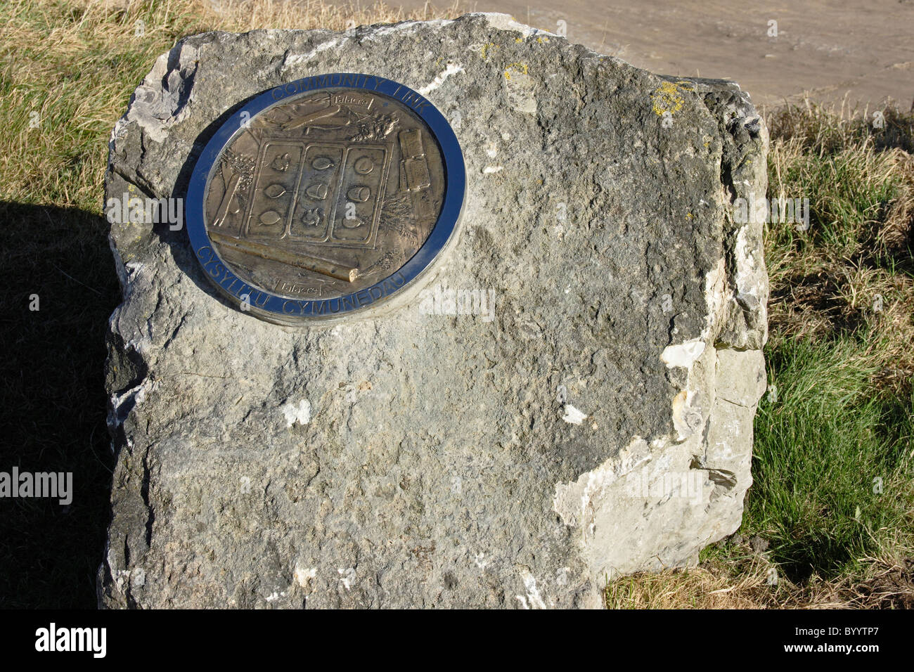 A welsh community link plaque attached to a stone on the beach at ...