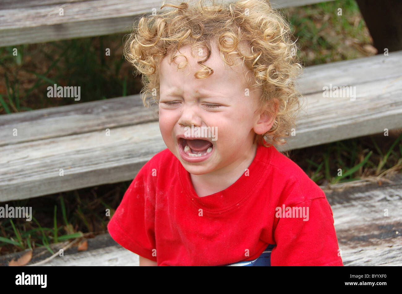 Young boy crying by steps Stock Photo - Alamy