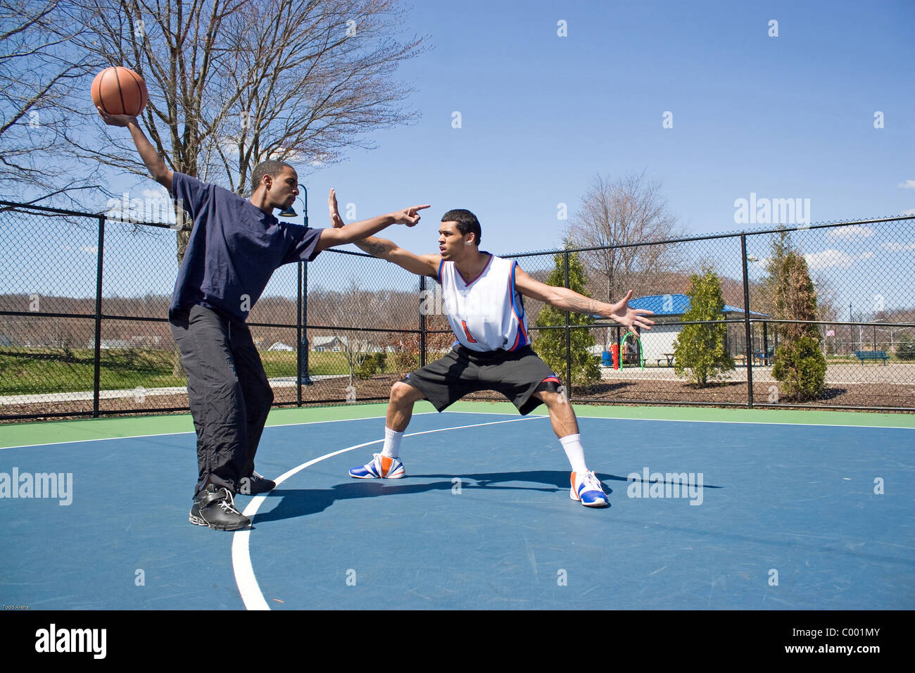 A young basketball player guarding his opponent during a one on one ...