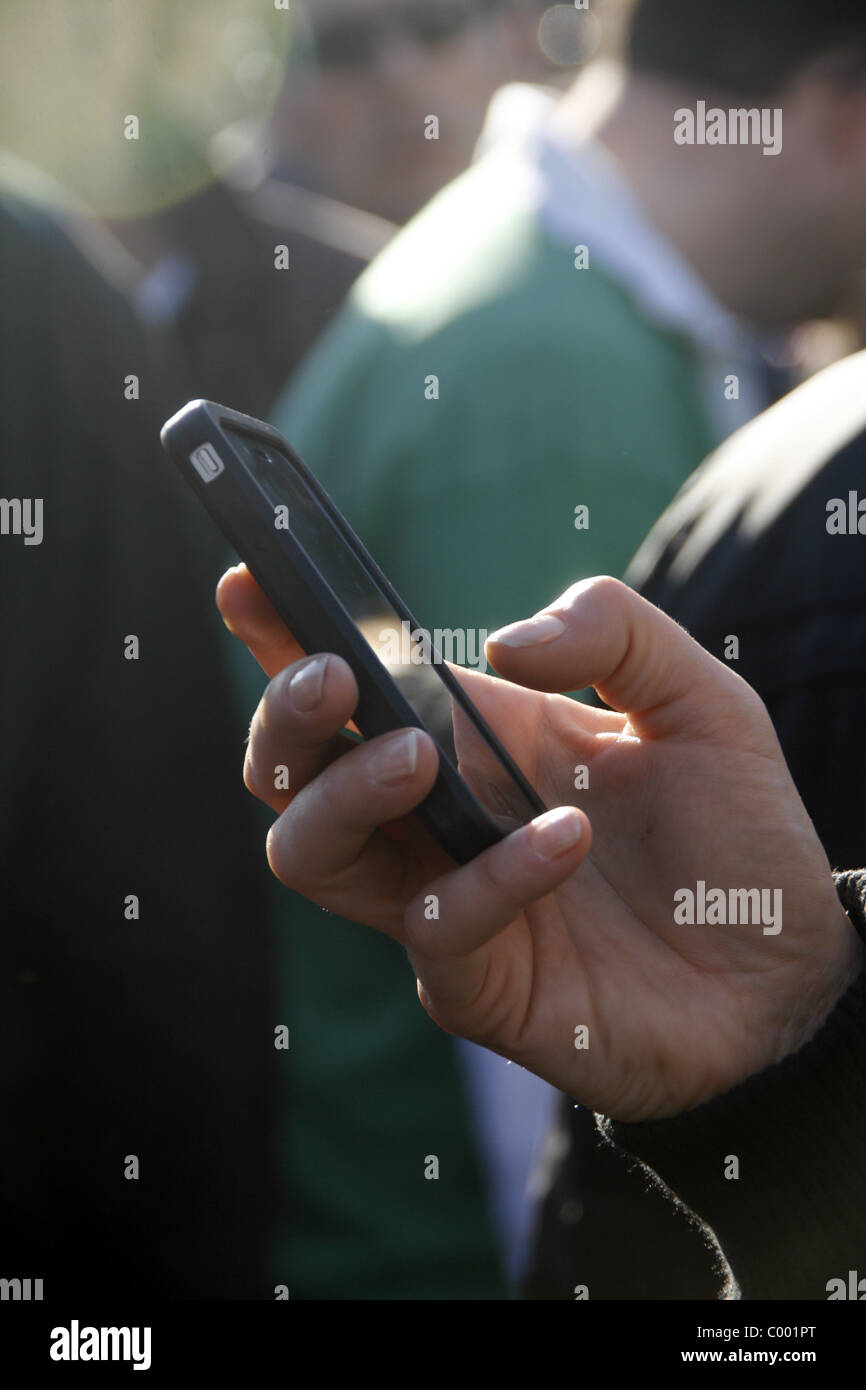 woman holding mobile phone in a crowd of people Stock Photo - Alamy