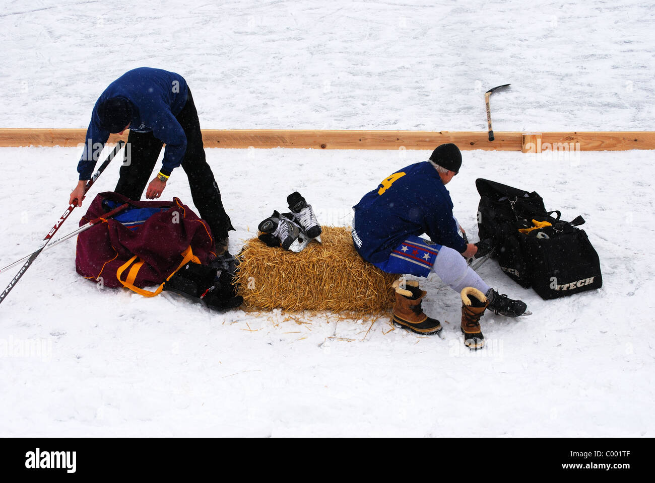 Players unpack hockey bag of gear at edge of outdoor ice rink Stock ...