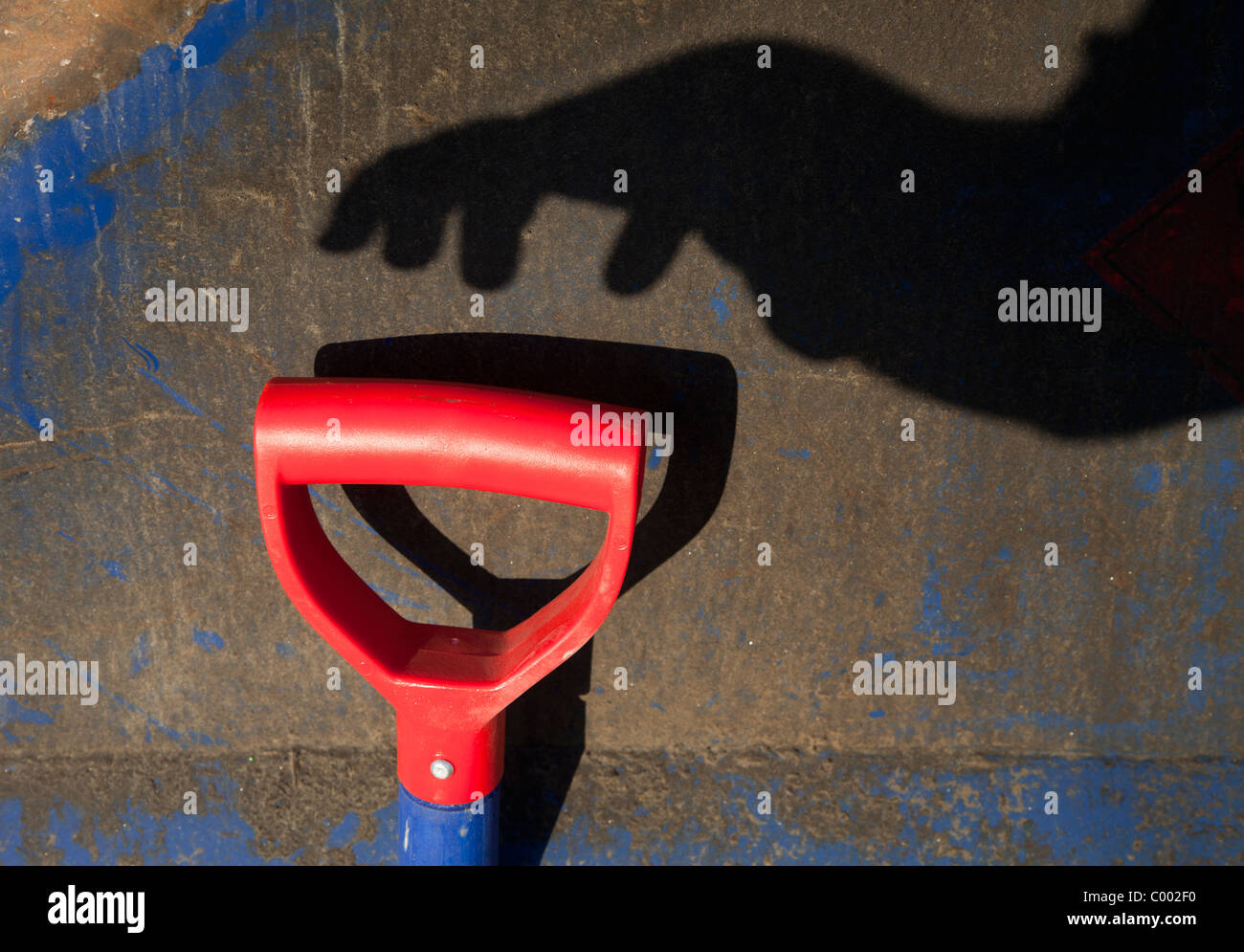 Spade and a shadow image of a hand Stock Photo - Alamy