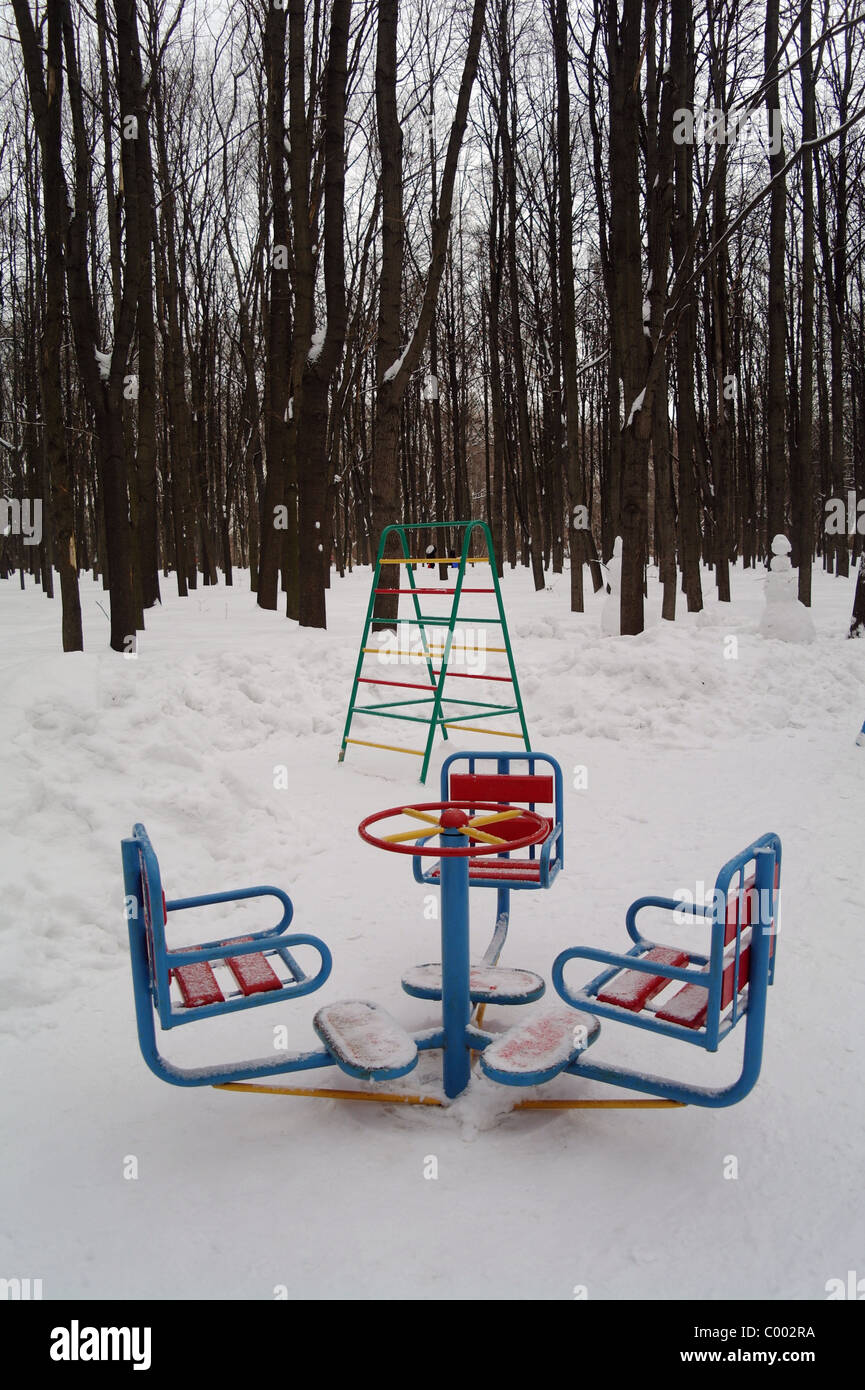 Children's roundabout in Not dull garden in the winter against trees ...