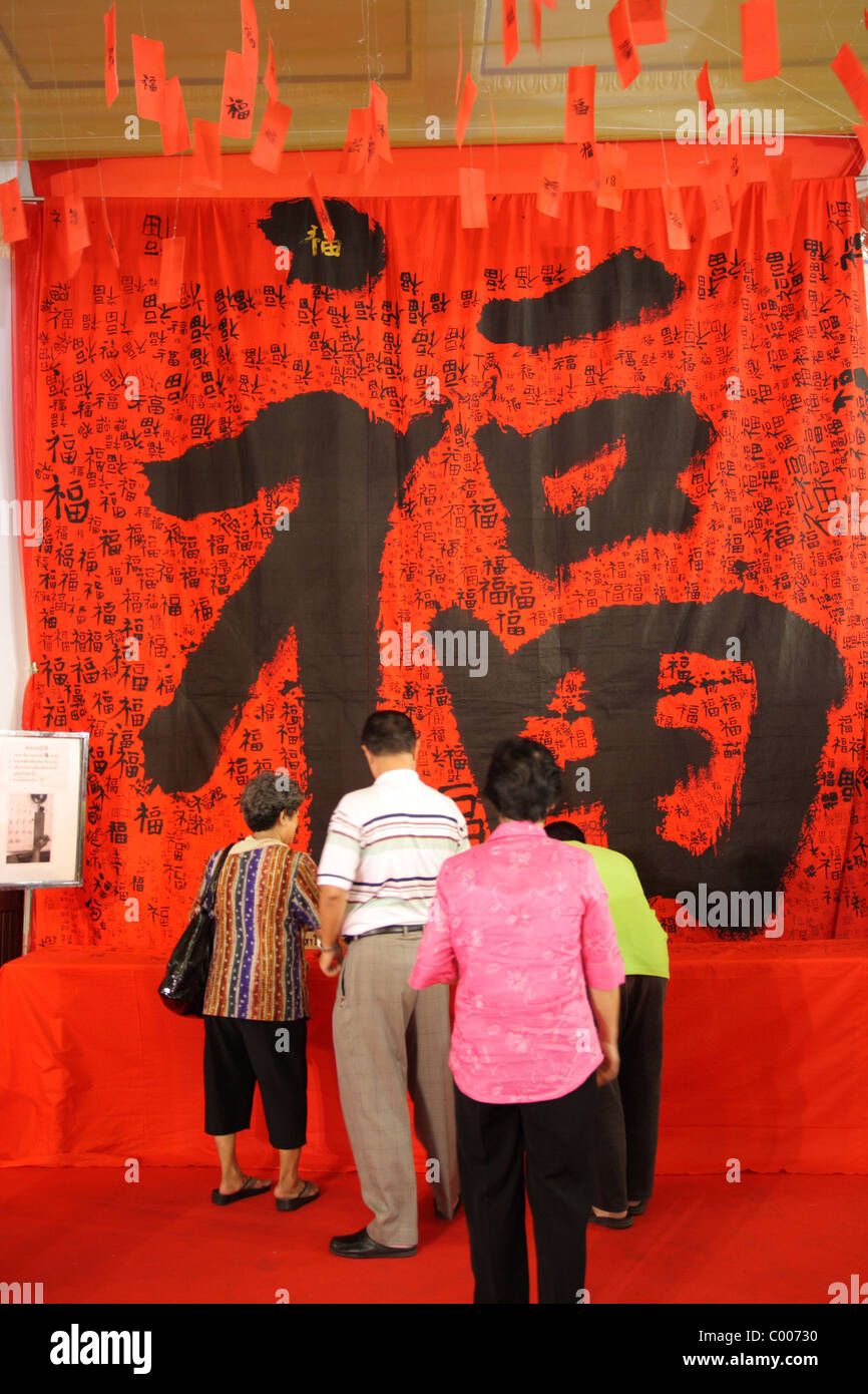 People writing Chinese Lucky Word on red fabric , Chinese new year ...