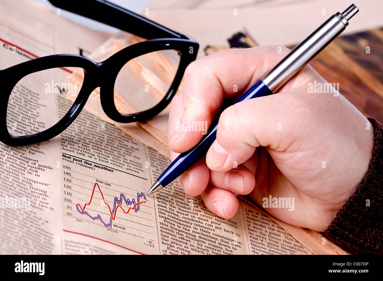 Checking daily market stock movement newspaper Stock Photo - Alamy