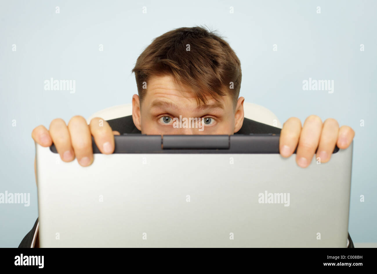 Accountant fear a tax audit - hiding behind a computer Stock Photo - Alamy