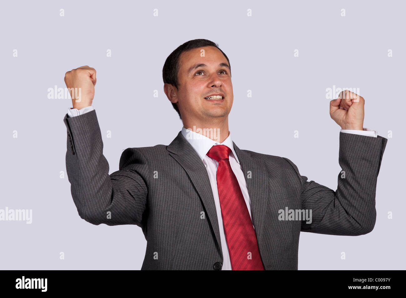 Happy businessman celebrating his success (grey background Stock Photo ...