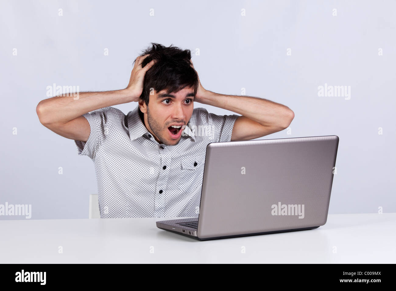 young man shocked with something he see on his laptop computer Stock ...