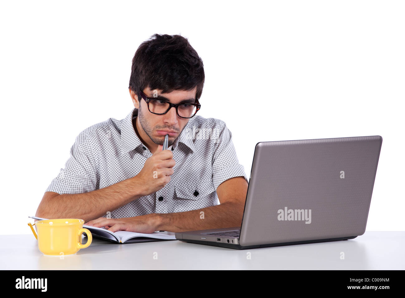 young man writing and looking to his laptop computer Stock Photo - Alamy