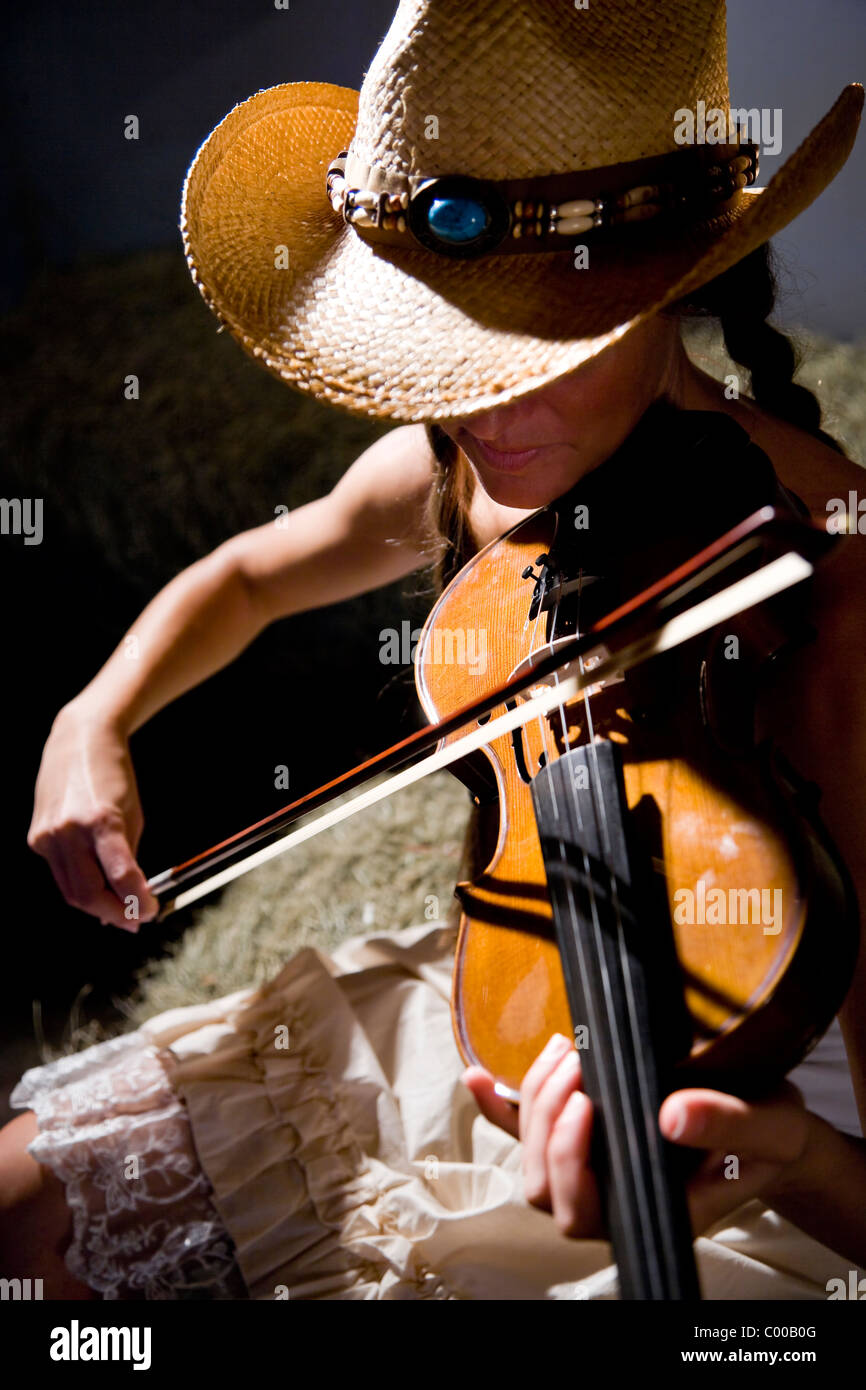 Moody cowgirl playing fiddle Stock Photo - Alamy