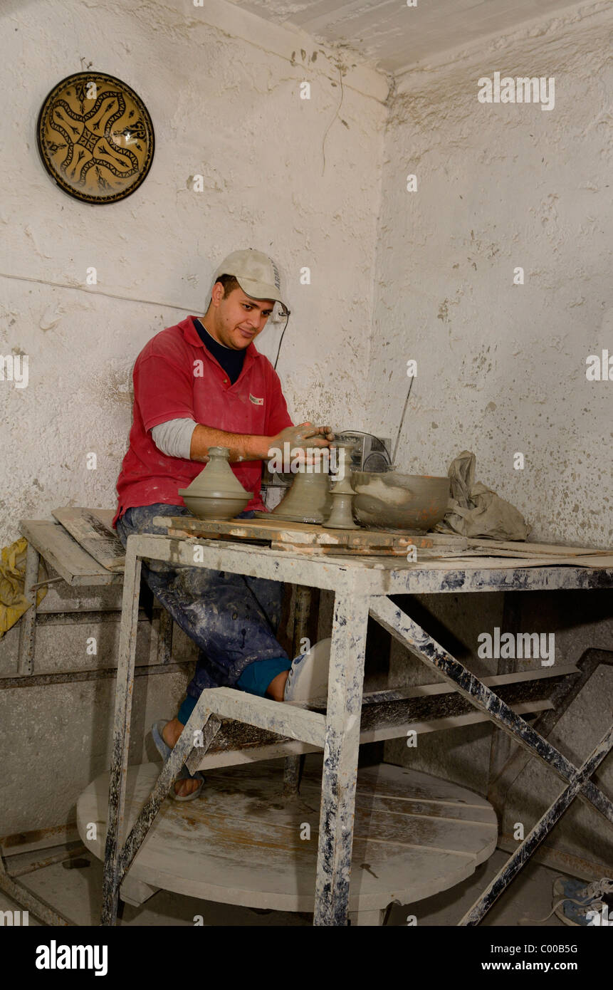 Worker throwing clay tagine pots on a turning wheel in a Fes el Bali ...