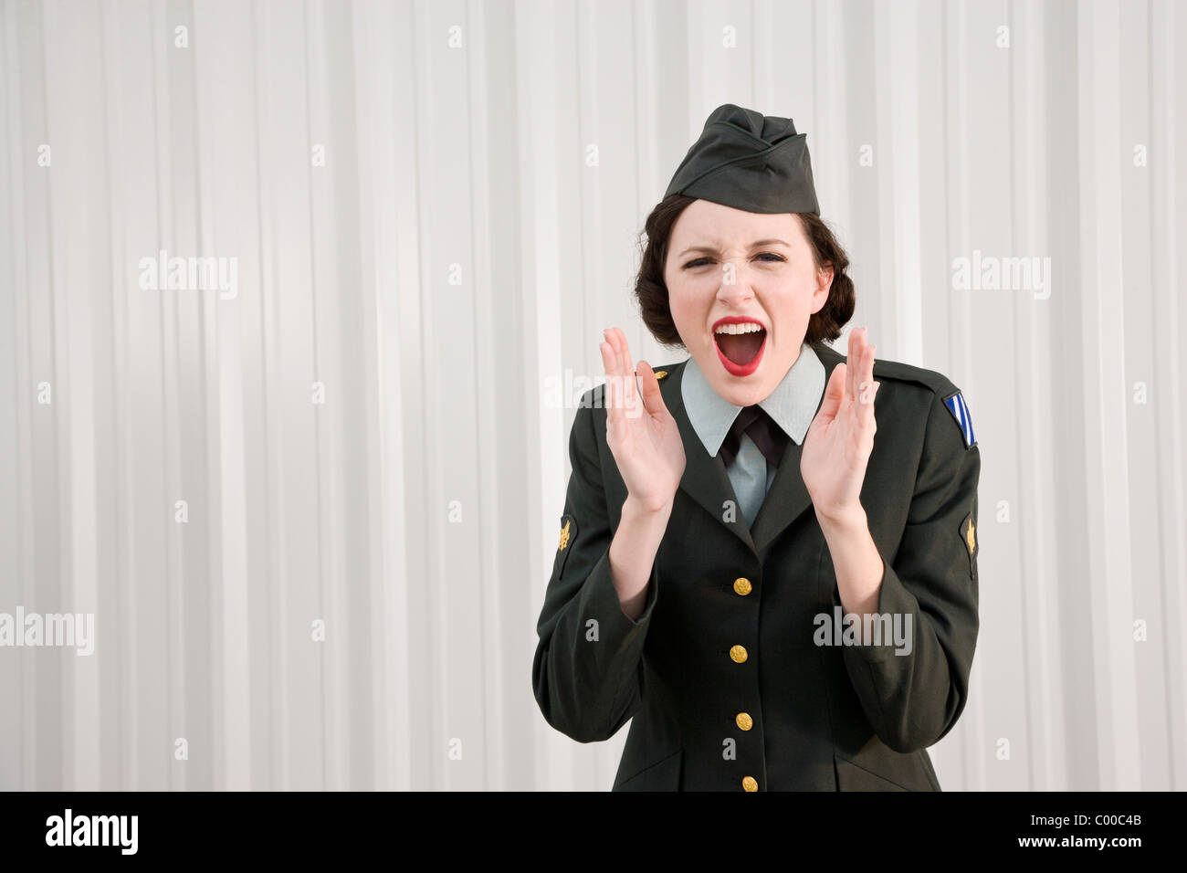 Young woman in retro army uniform shouting Stock Photo - Alamy