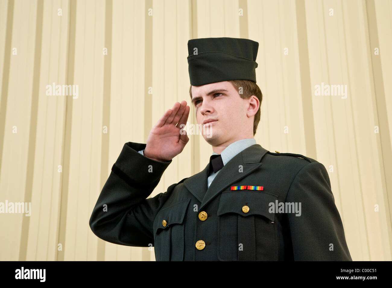 Young man in retro army uniform saluting Stock Photo - Alamy