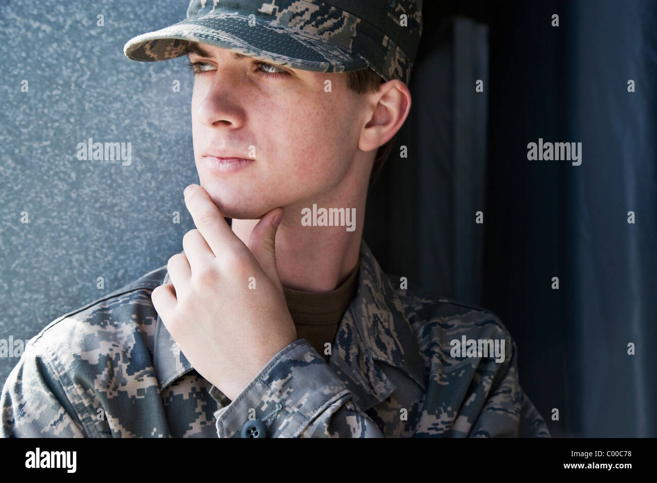 Young man in army combat uniform thinking Stock Photo - Alamy