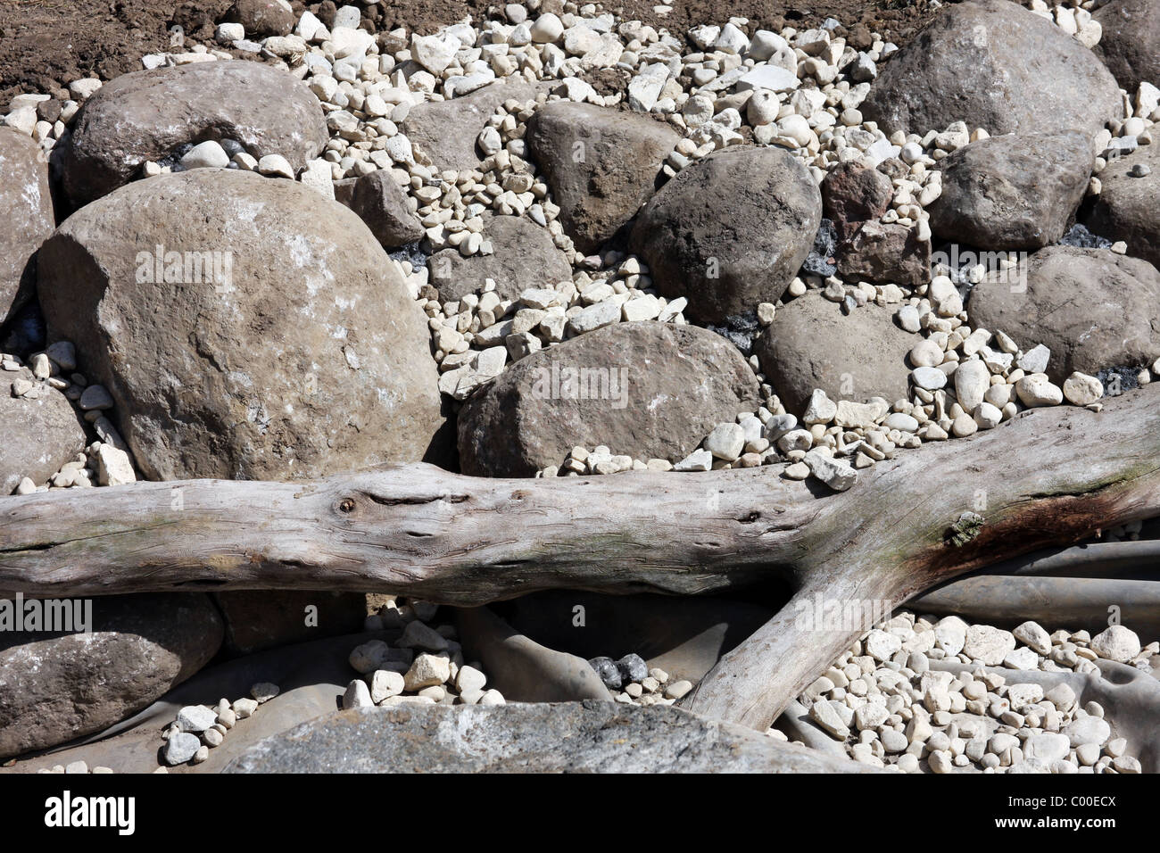 Rocks and logs on the bottom of a riverbed landscaping project Stock ...