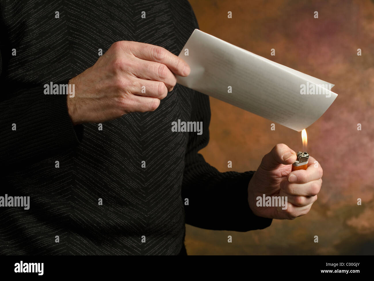 man holding butane lighter to folded document Stock Photo - Alamy