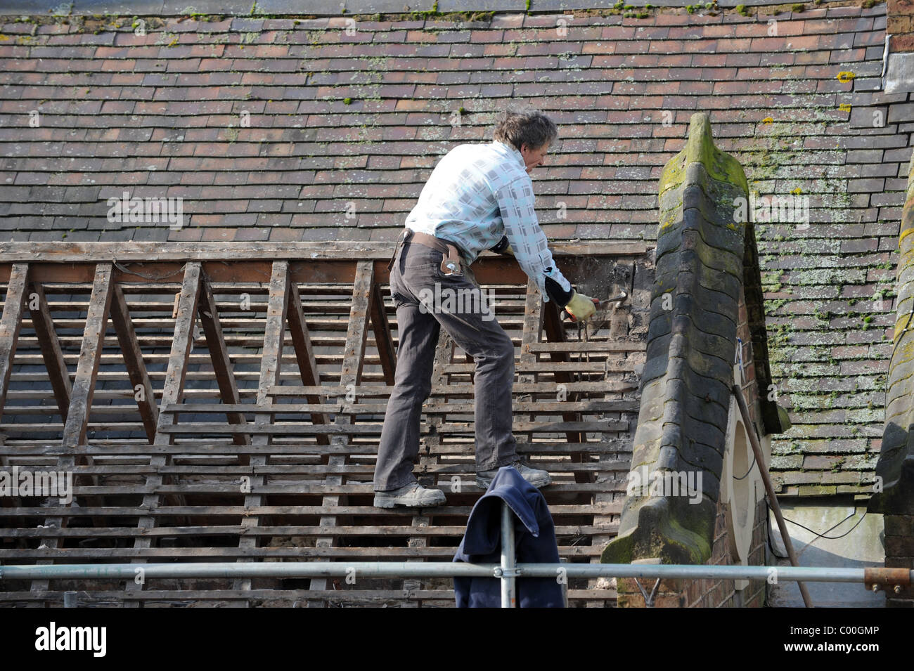 Builders repairing roof on old house England Uk Stock Photo - Alamy