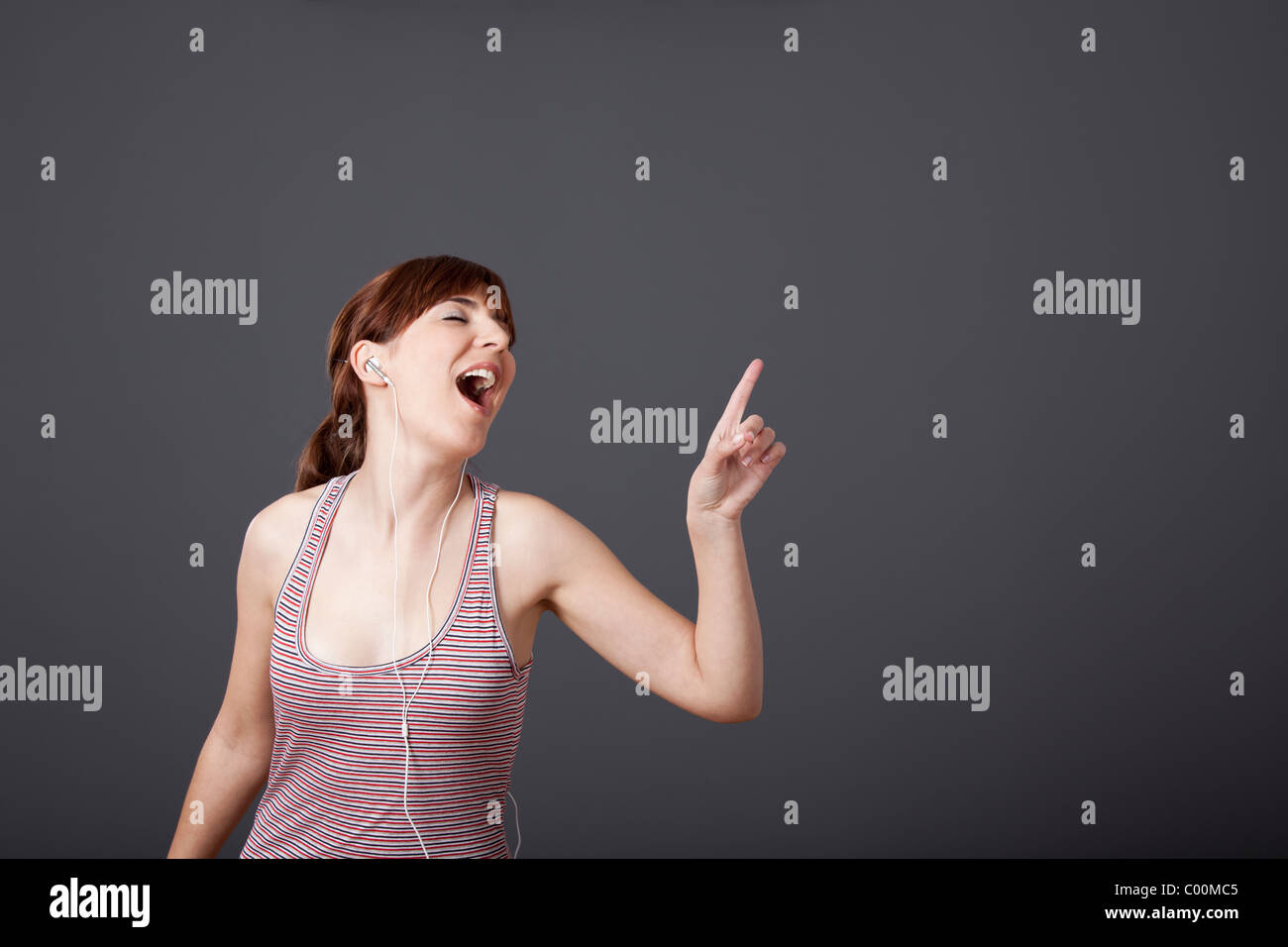 Happy young woman dancing and singing while listen music Stock Photo ...