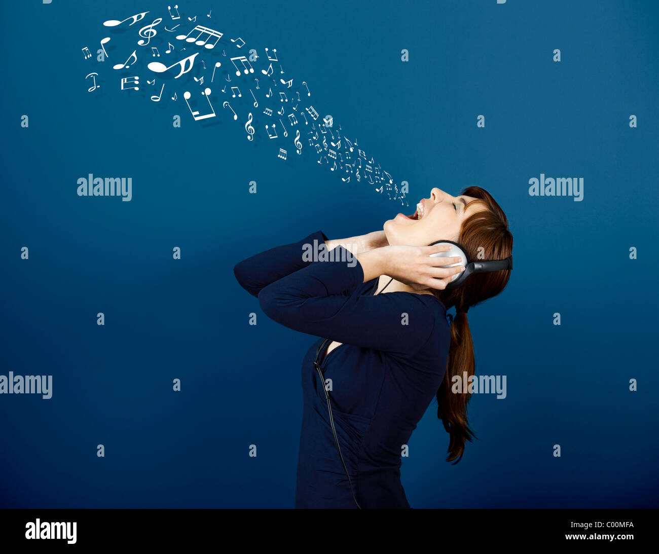 Young woman singing and listen music with musical notes getting out of ...