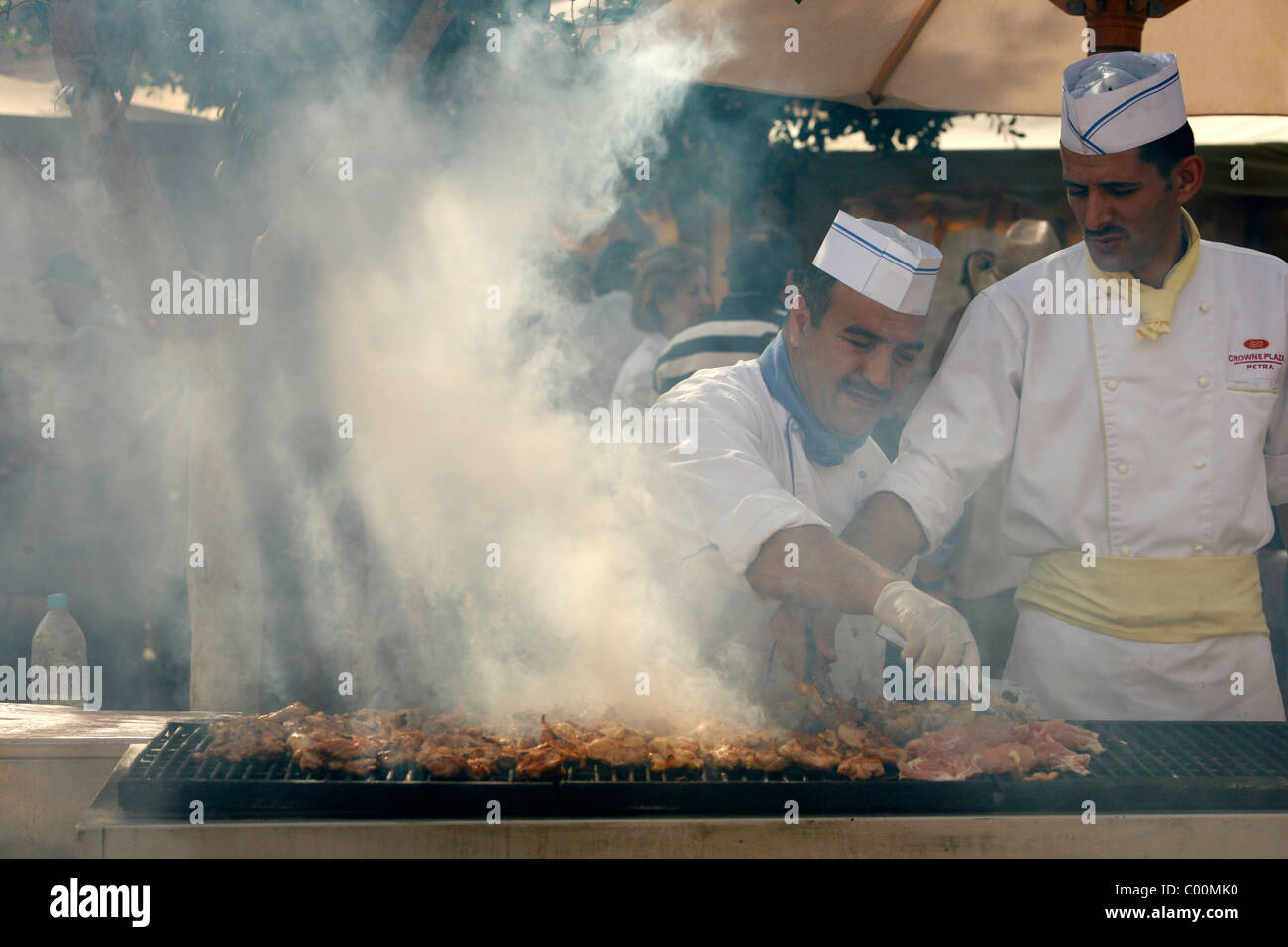 Cook at Basin restaurant prepearing grilled chicken, Petra, Jordan ...
