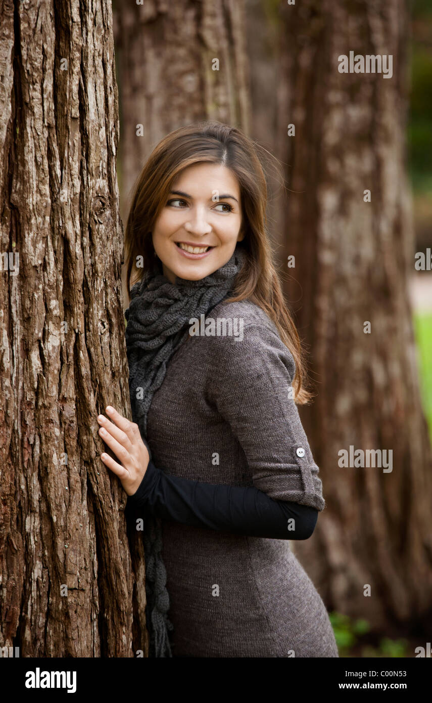Portrait of a beautiful young woman posing near a tree Stock Photo - Alamy