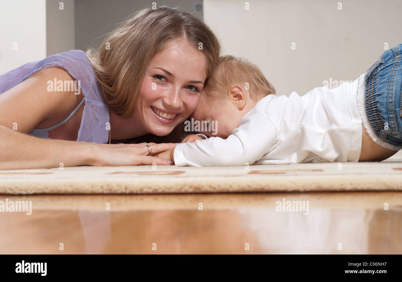 Young mother is lying down with her playful son Stock Photo - Alamy
