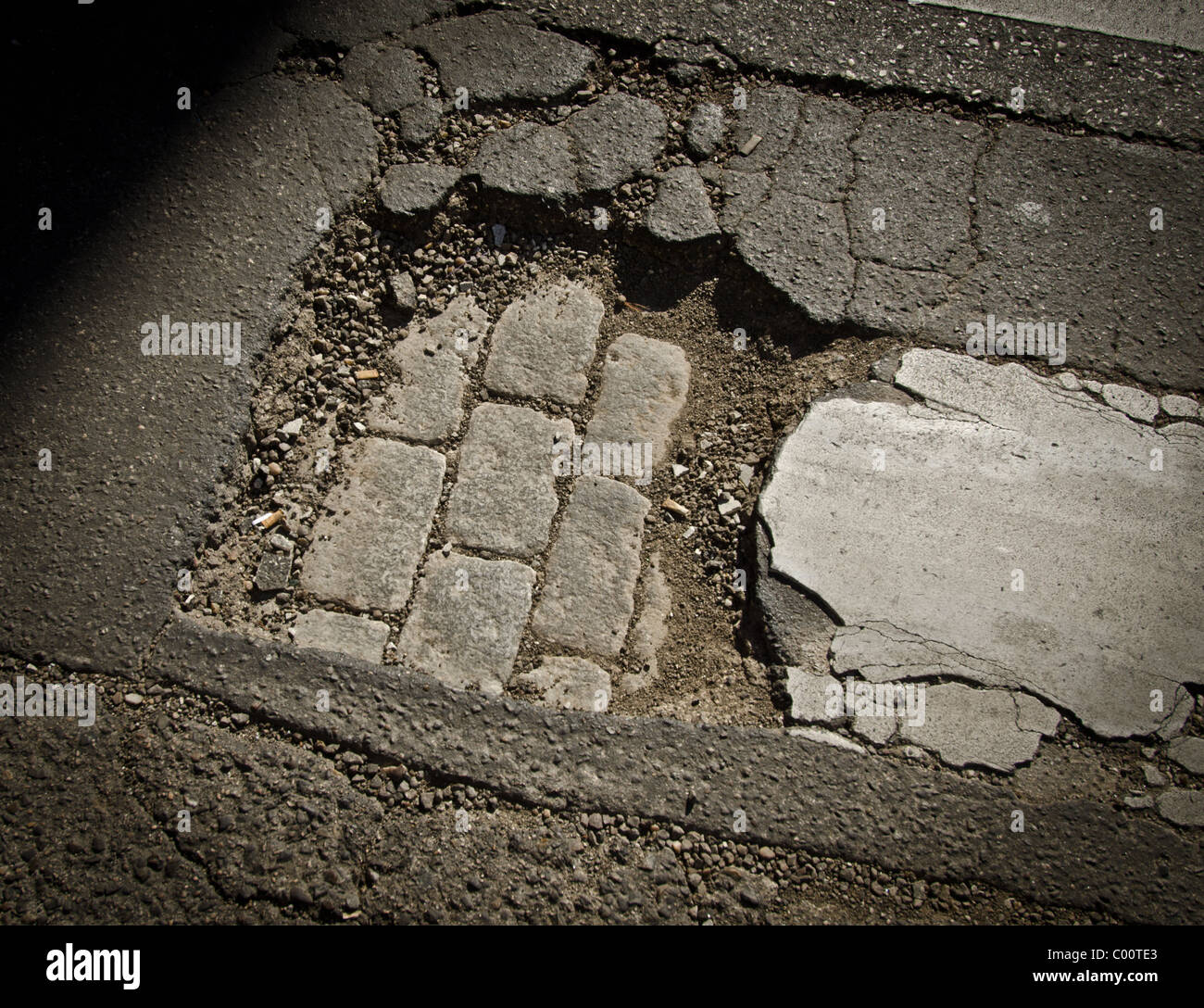 Damaged road surface showing different layers of surfaces Stock Photo ...