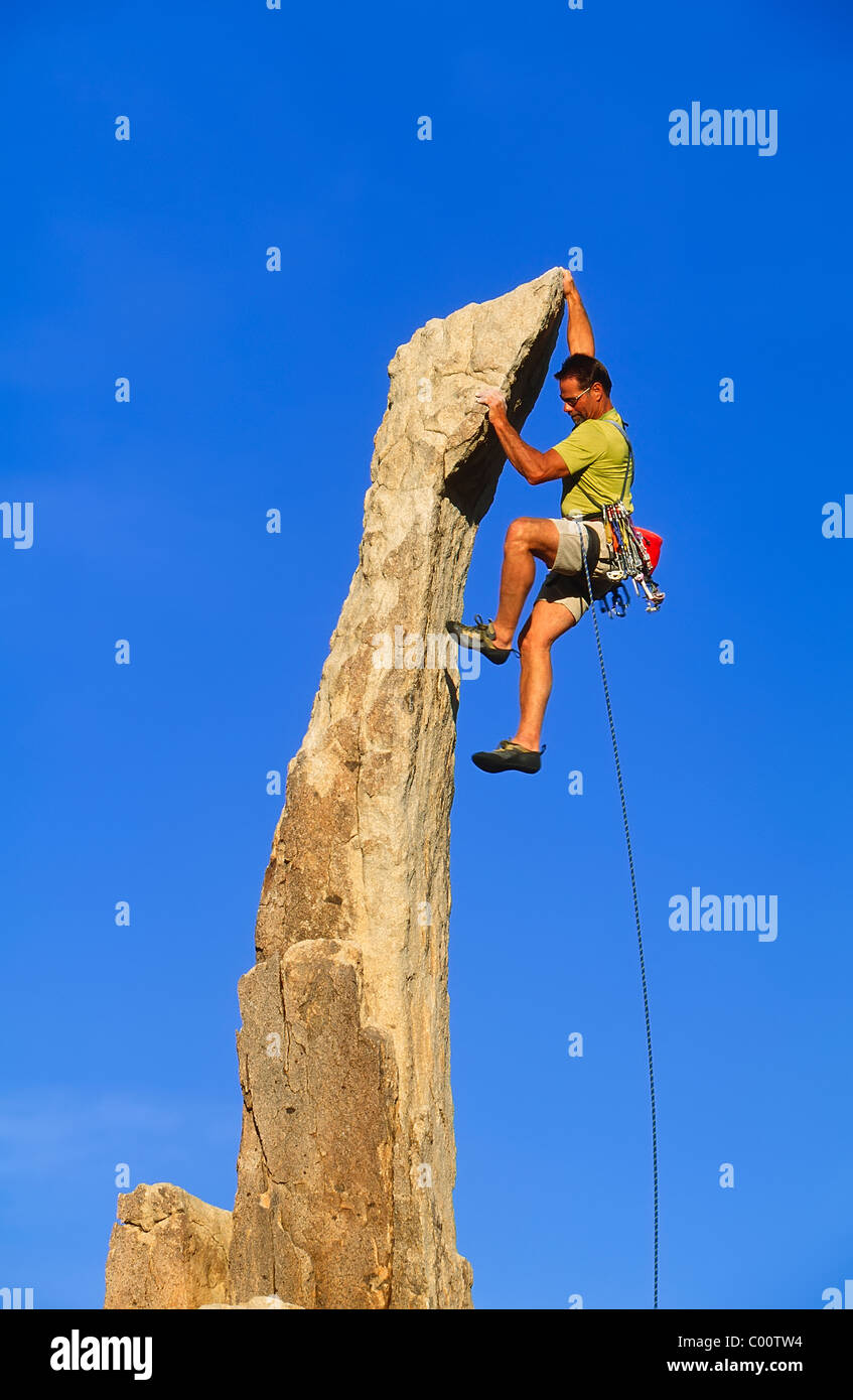 Male rock climber clinging to a cliff Stock Photo - Alamy