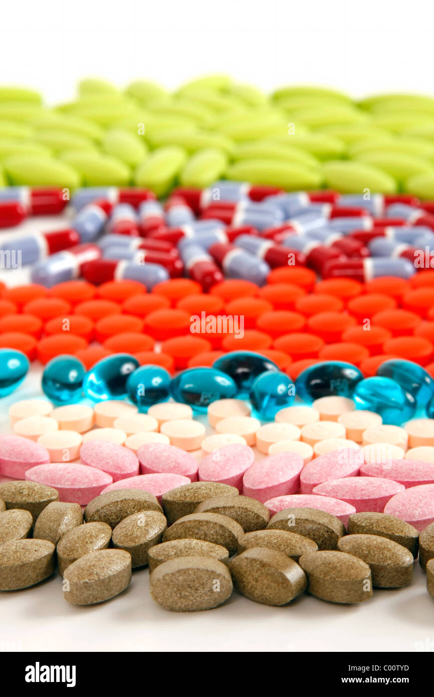 Different colored and shaped pills lined up on a white background Stock ...