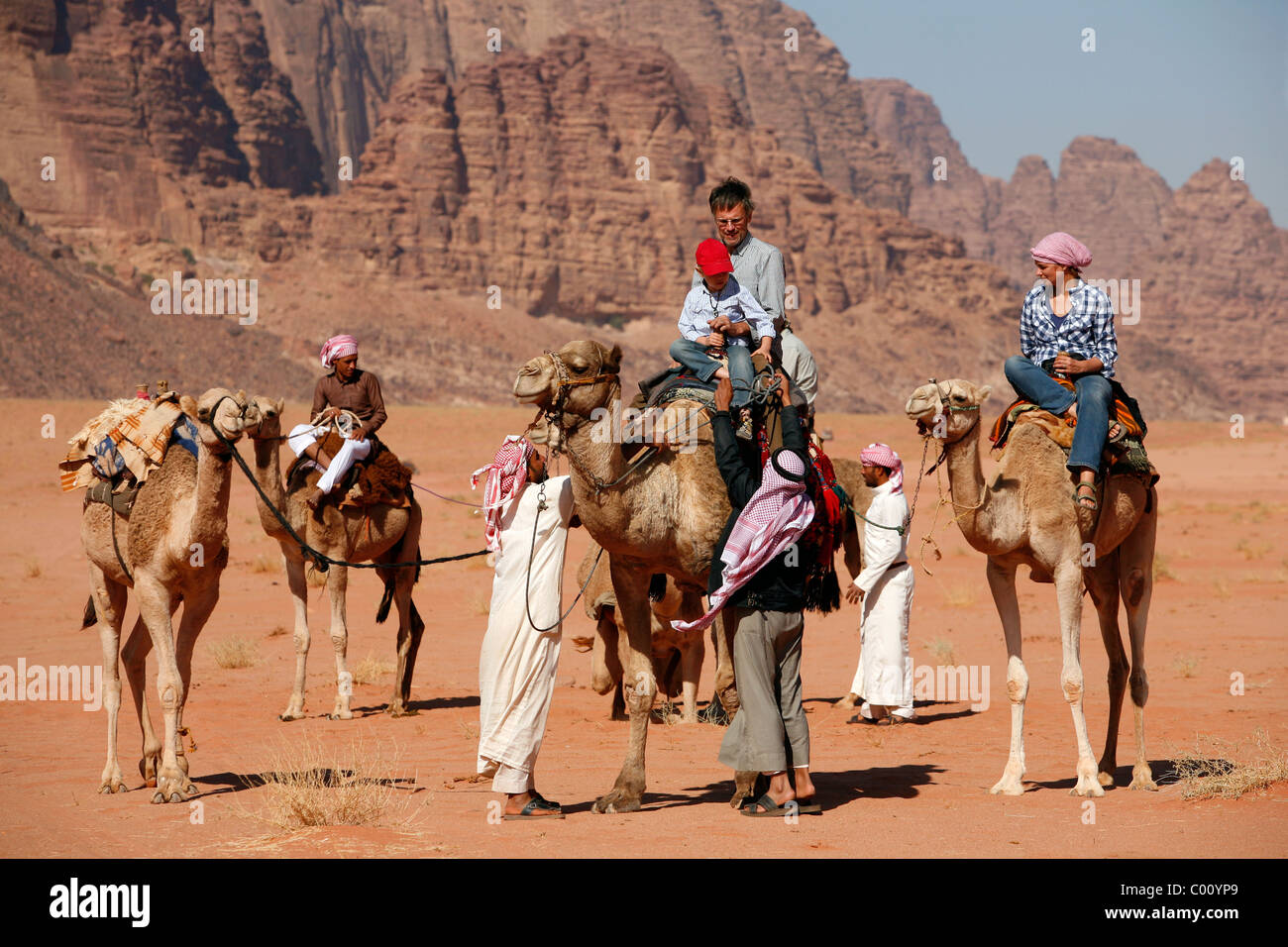 Tourists riding camels in the desert, Wadi Rum, Jordan Stock Photo - Alamy