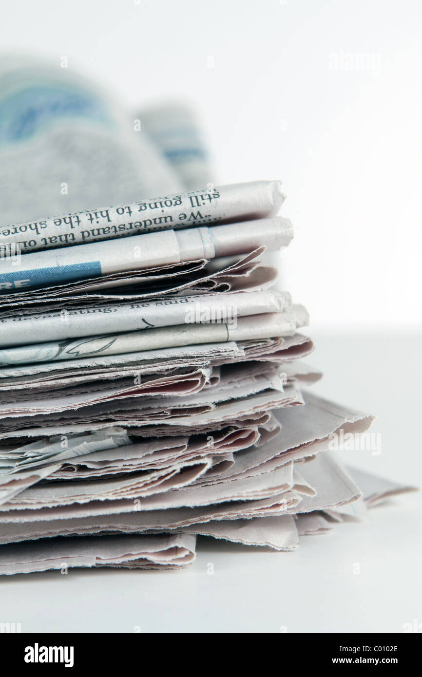 Stack of newspapers sit on a white background in vertical format Stock ...