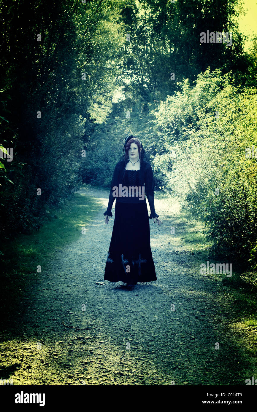 Red-haired woman, Gothic, walking down a path, retro Stock Photo - Alamy