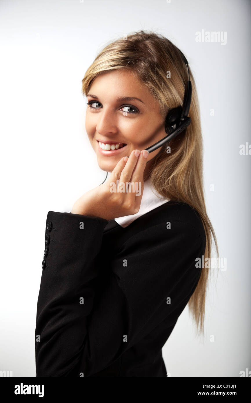 Young customer service representative with telephone headset on smiles ...