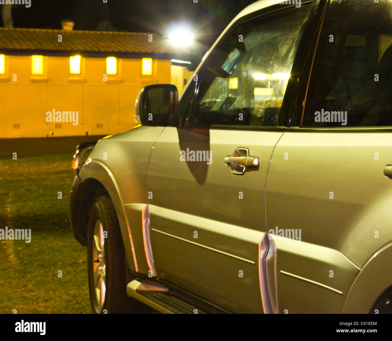 Car at night with building in background Stock Photo - Alamy