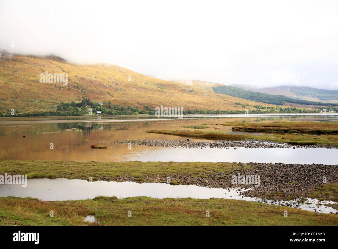 Lake view towards the mist covered mountains in Scotland Stock Photo ...