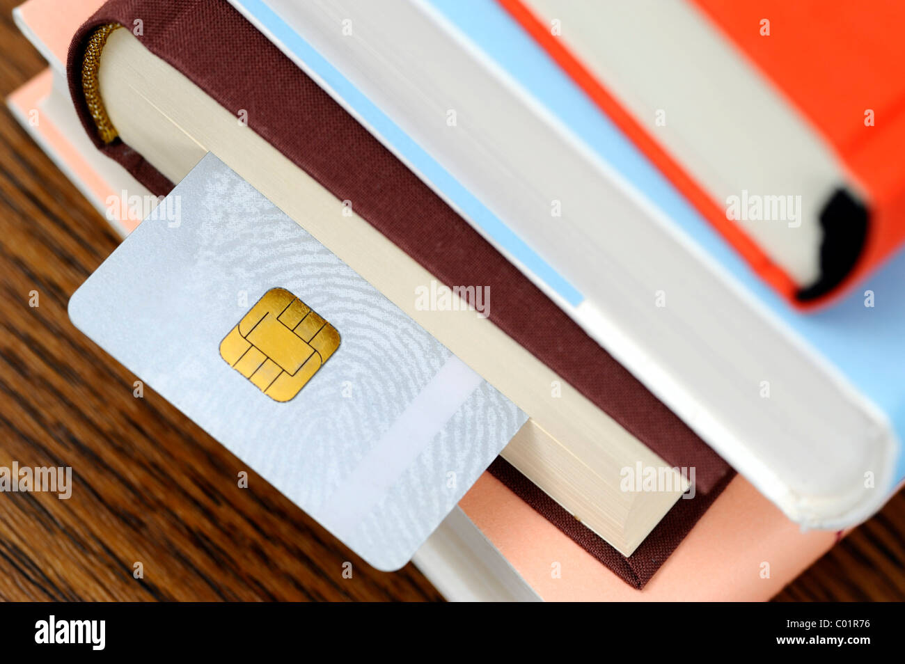 Smart card in a stack of books, symbolic image for an educational smart ...
