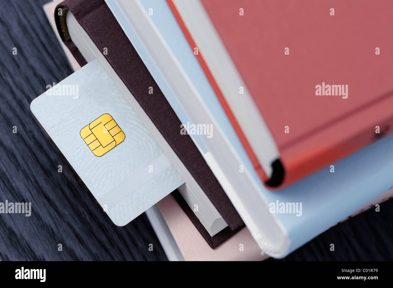 Smart card in a stack of books, symbolic image for an educational smart ...