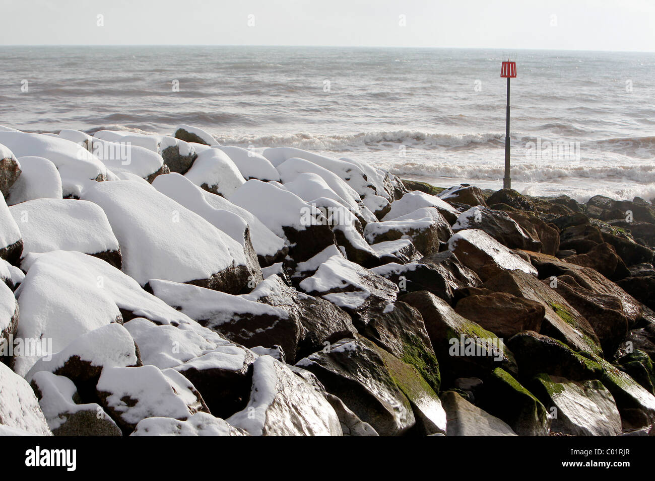 Snow covered rocks on a beach in Devon Stock Photo - Alamy