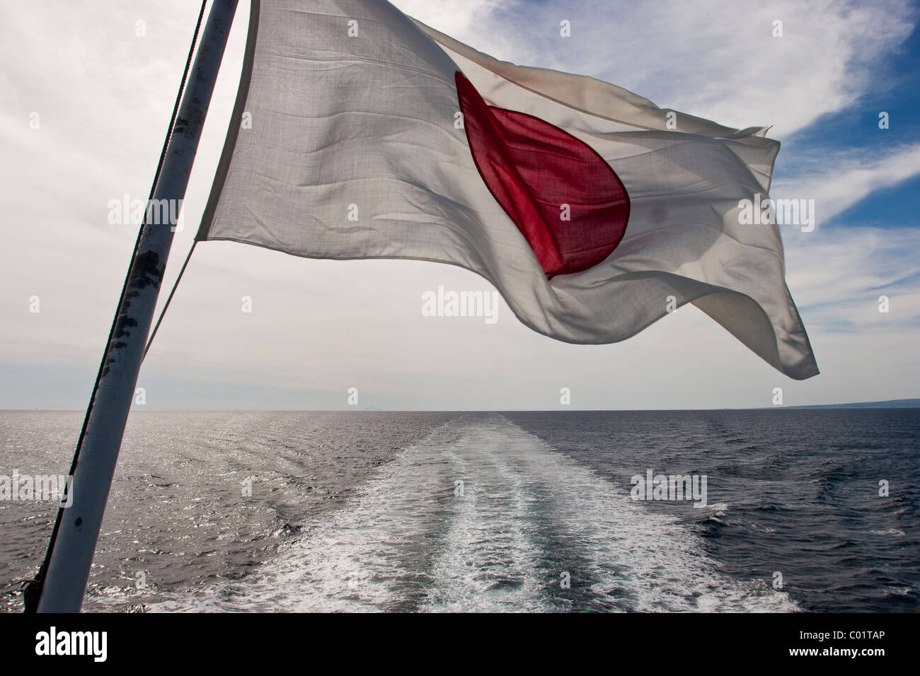 A Japanese flag flies off the stern of the ferry as it crosses from ...