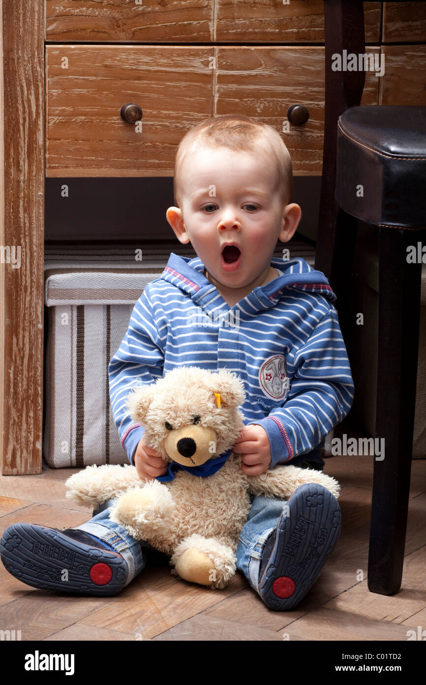 Boy, baby, 8 months, yawning, with a teddy bear Stock Photo - Alamy