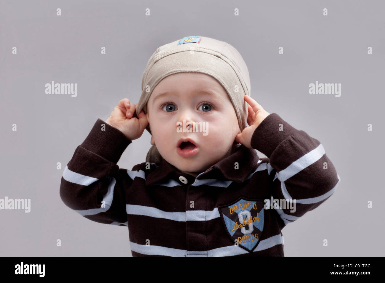 Baby drawing a cap to his face, boy, 8 months, portrait Stock Photo - Alamy