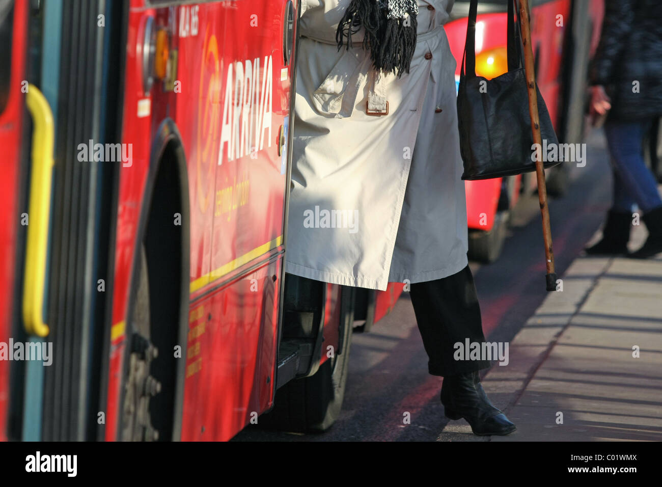 A person stepping from a red London bus Stock Photo - Alamy